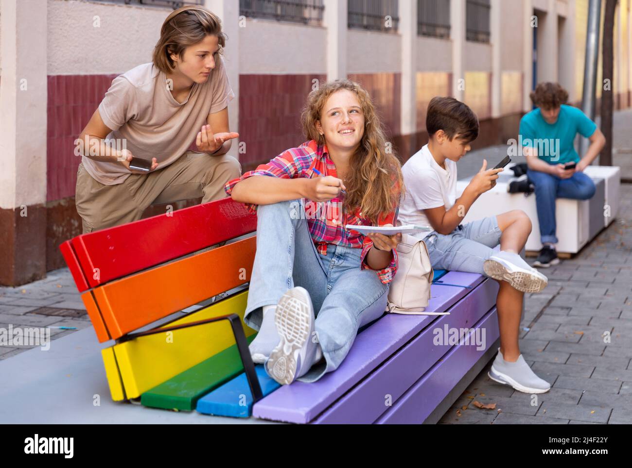 Group of teenagers sitting on bench outdoors Stock Photo - Alamy