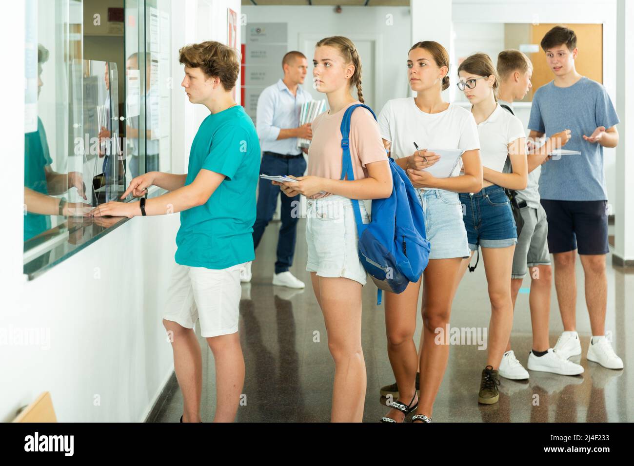 Teenage students queuing at front office on college campus Stock Photo ...