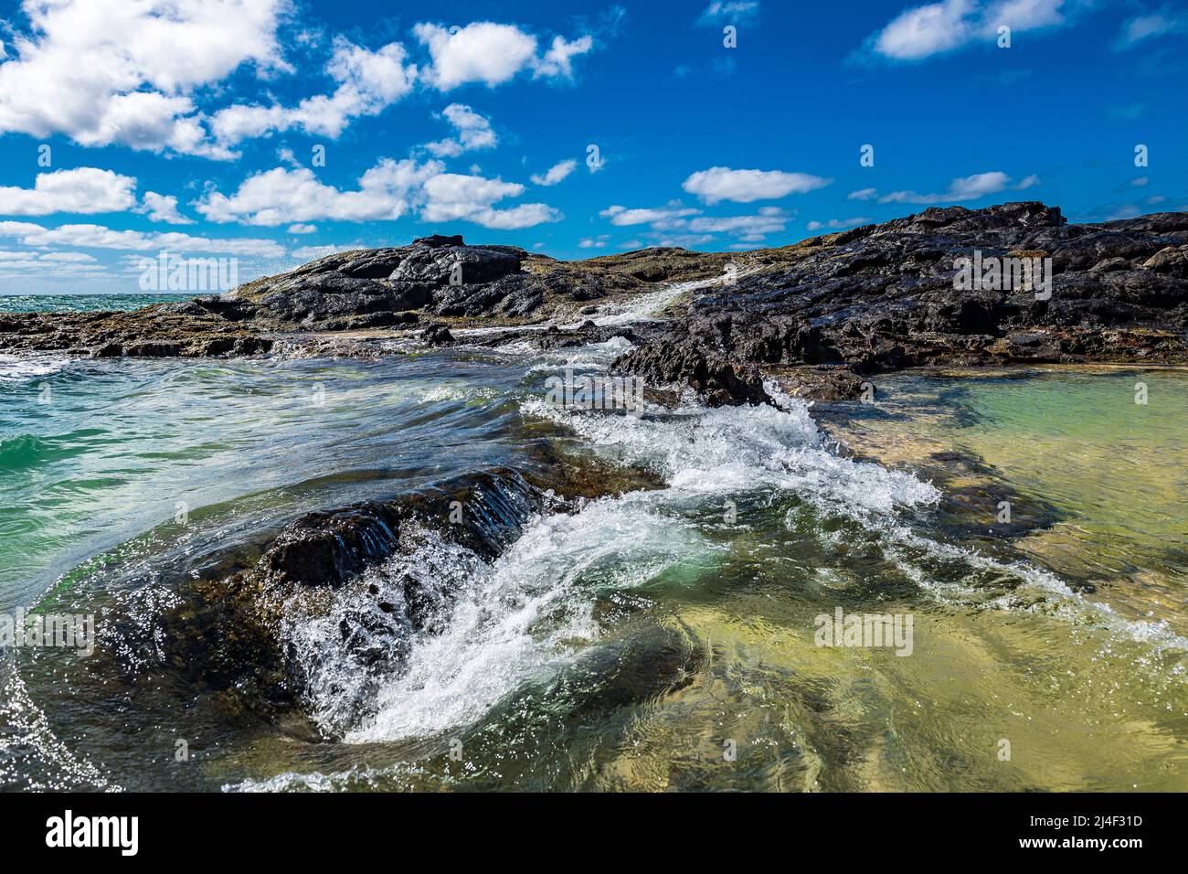 Water cascades over the rocks and the famous Champagne Pools on Fraser ...