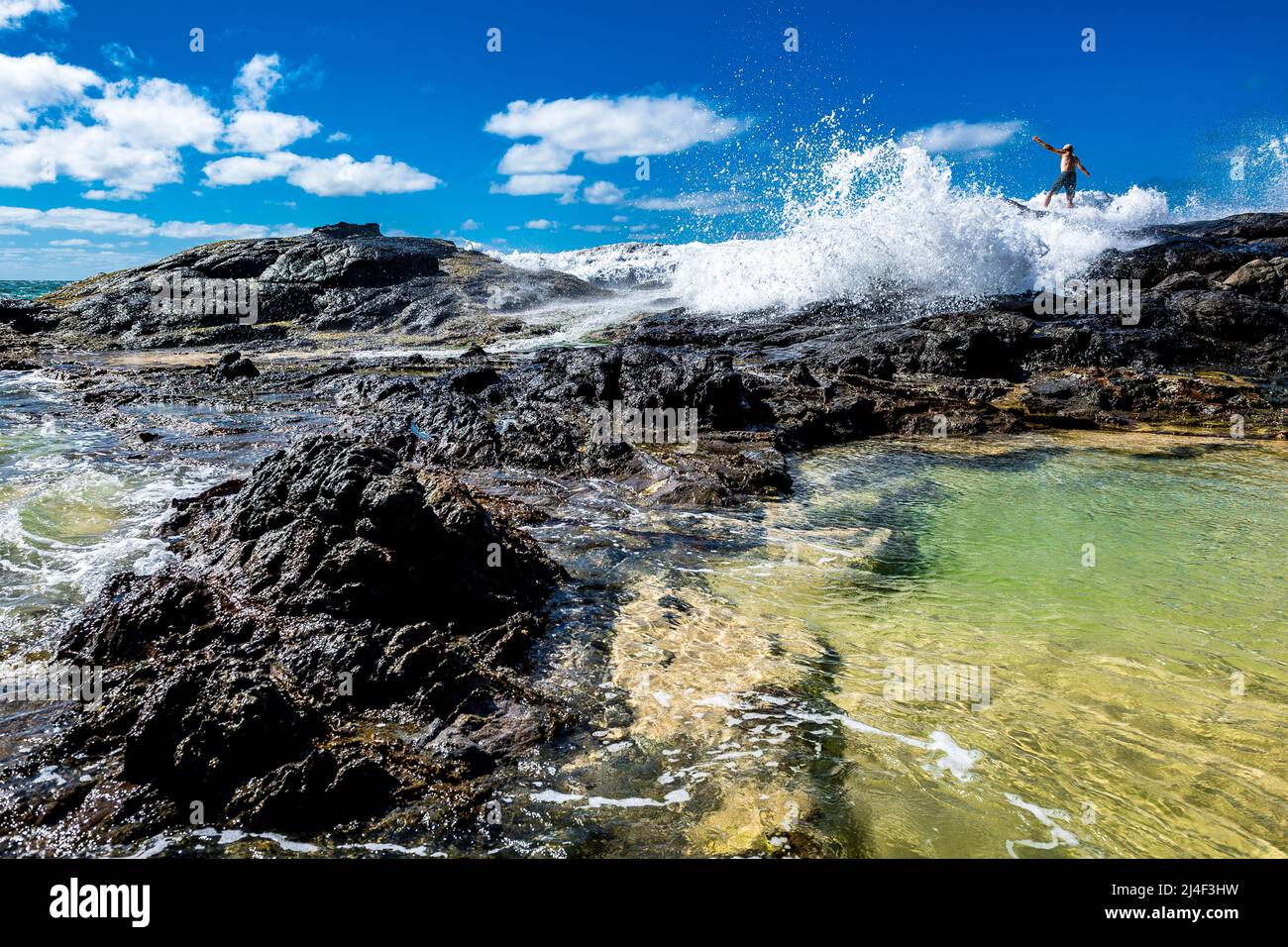 A male tourist enjoying the sun and water at Champagne Pools on Fraser ...