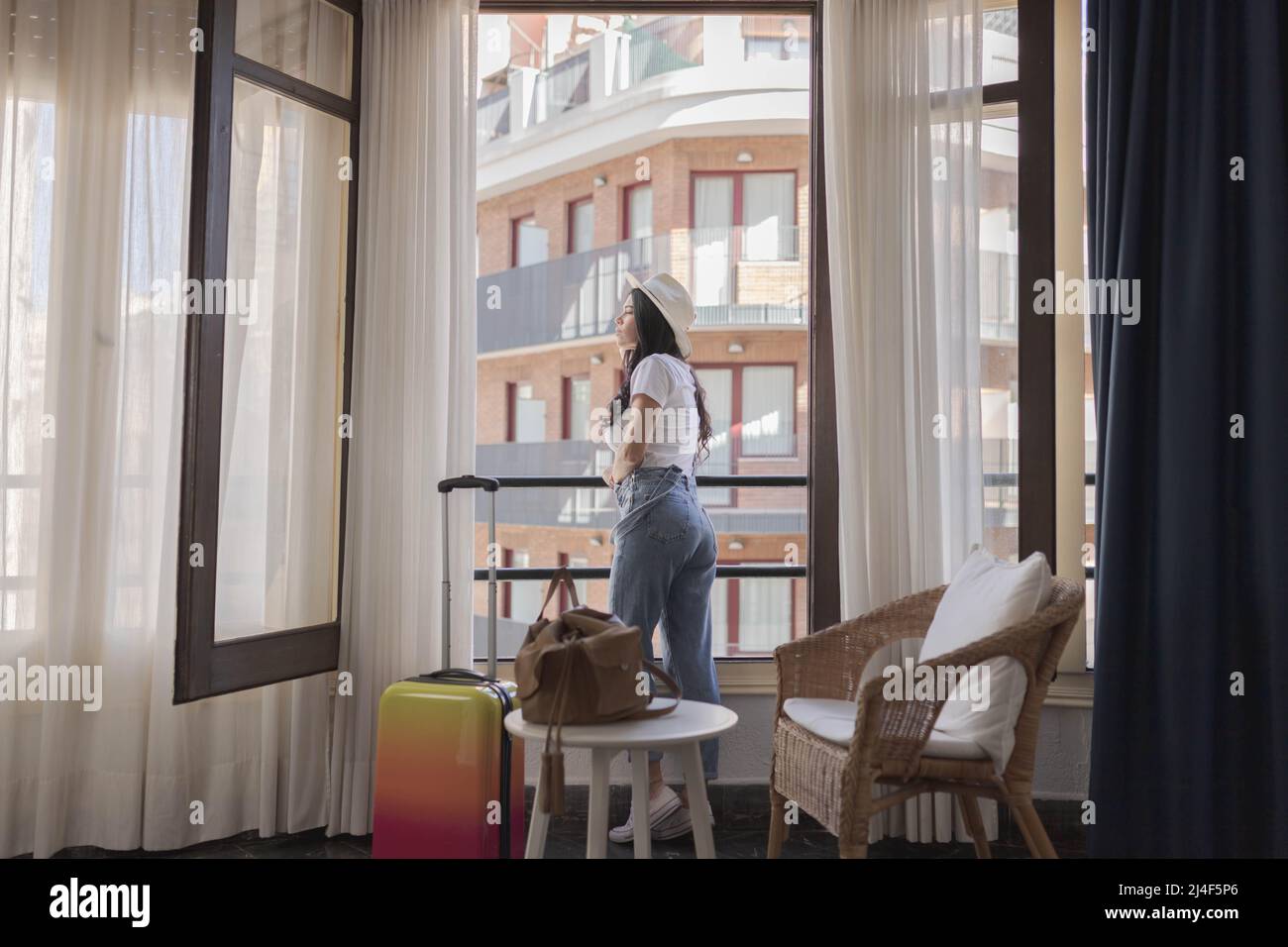 Happy rich young woman wear night robe stand at big window open lace ...