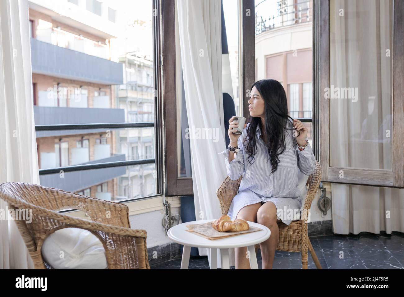 Happy rich young woman wear night robe stand at big window open lace ...