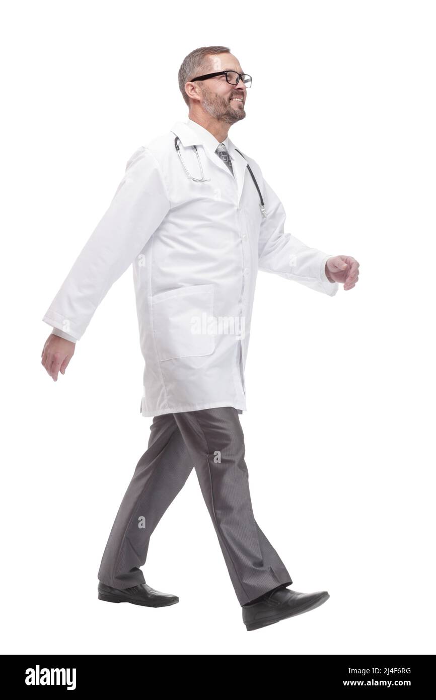 Mature male doctor striding forward. isolated on a white background ...