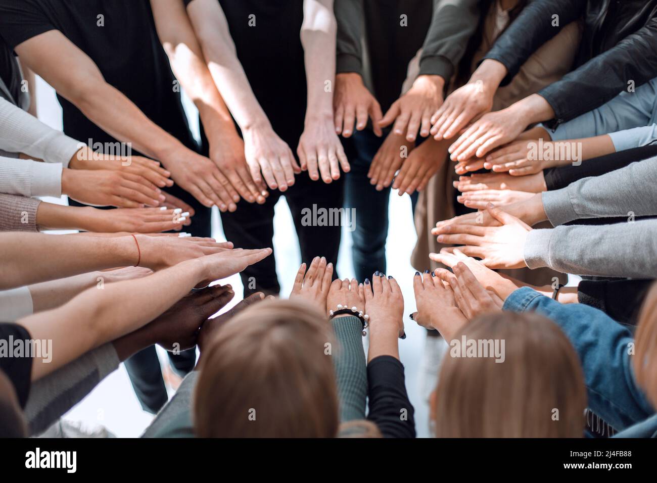 background image of a group of people joining their hands in a circle ...