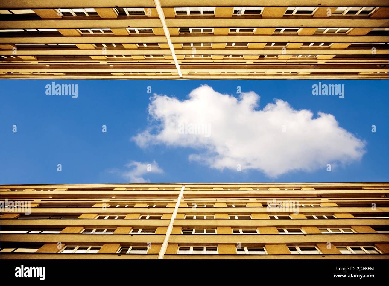 low angle view of two buildings facing each other, with a blue sky with ...