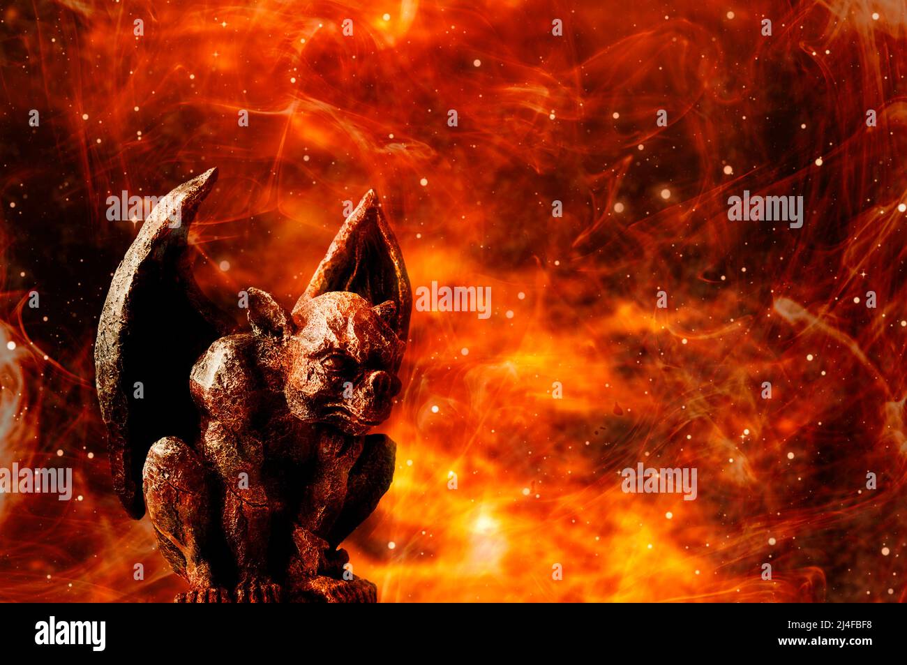 winged gargoyle statue with a fire background Stock Photo - Alamy
