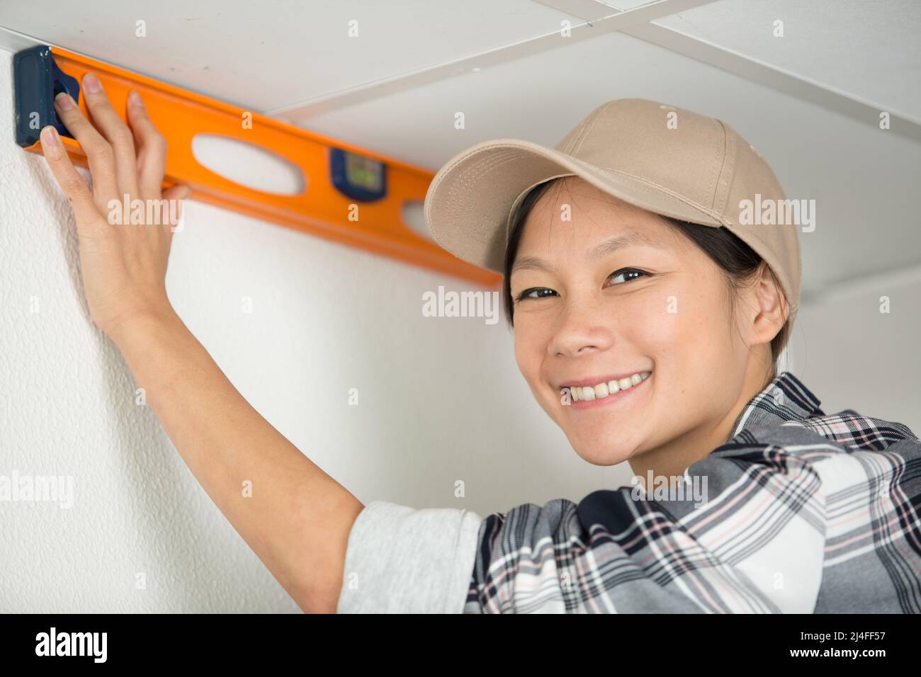 woman with level measurement at the wall Stock Photo - Alamy
