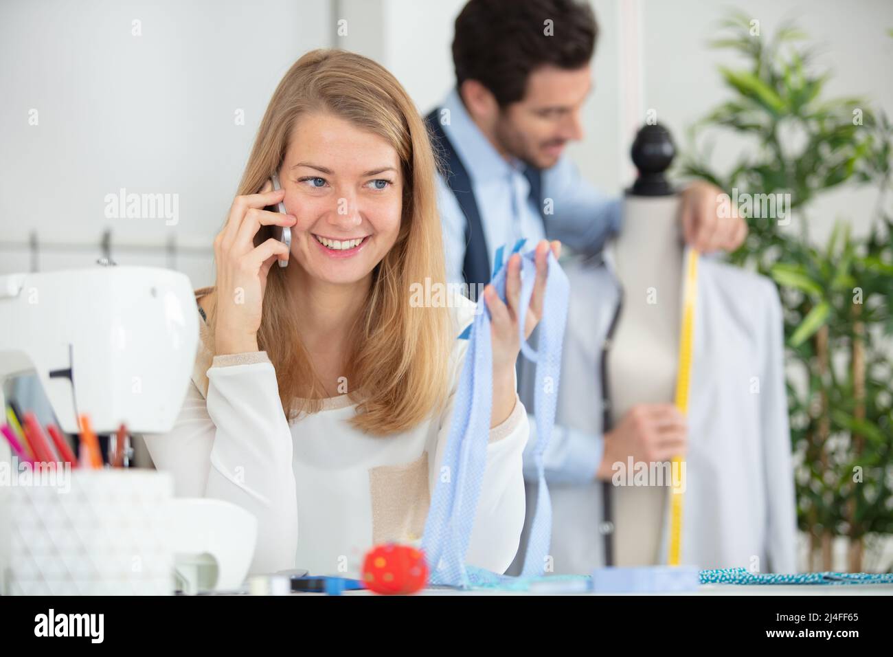 fashion designer making phonecall in her studio Stock Photo - Alamy