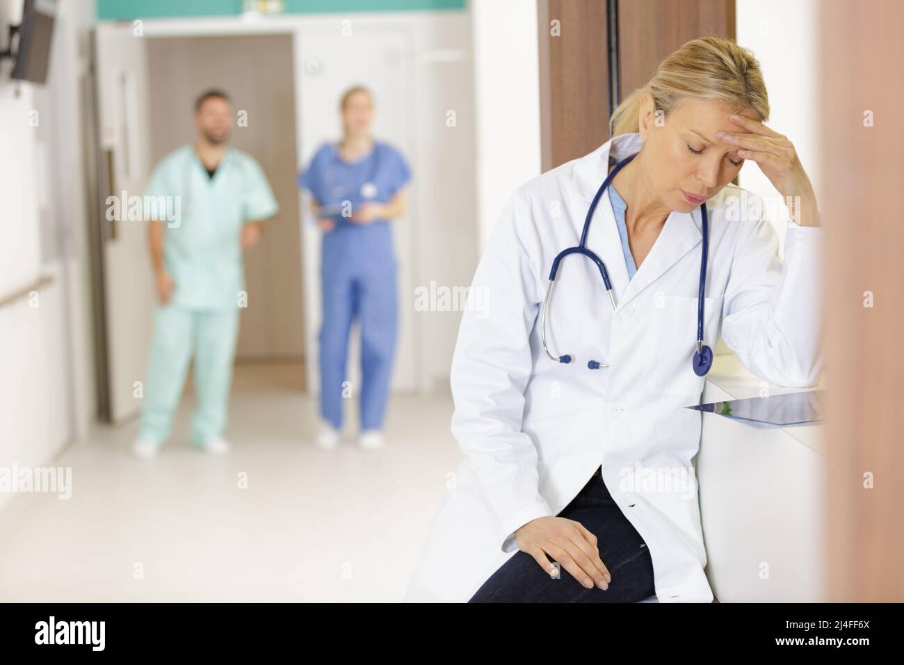 nurse doctor with migraine overworked overstressed in hospital hall ...