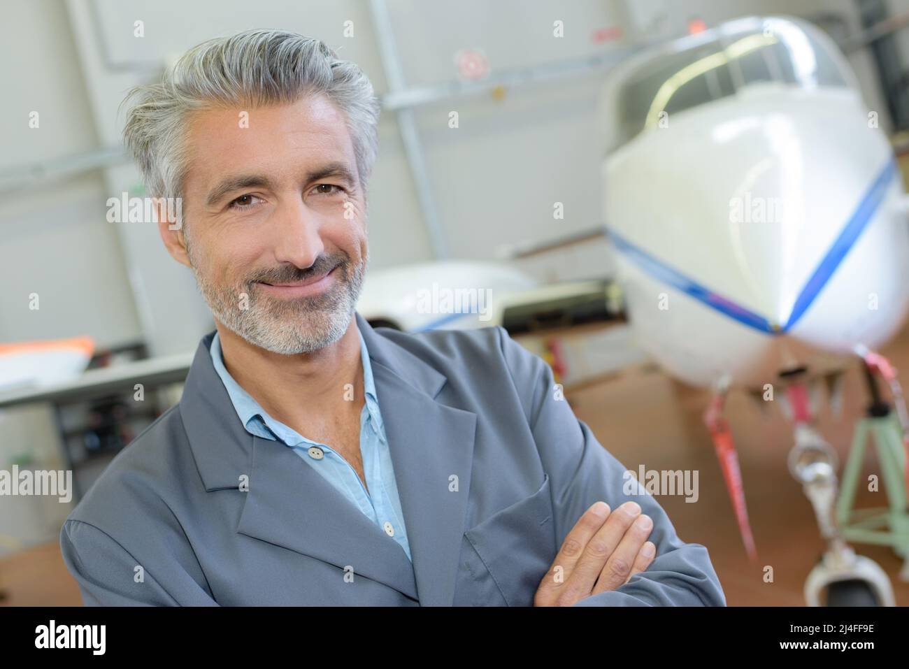 smiling handsome pilot posing at the hangar with motor airplane Stock ...