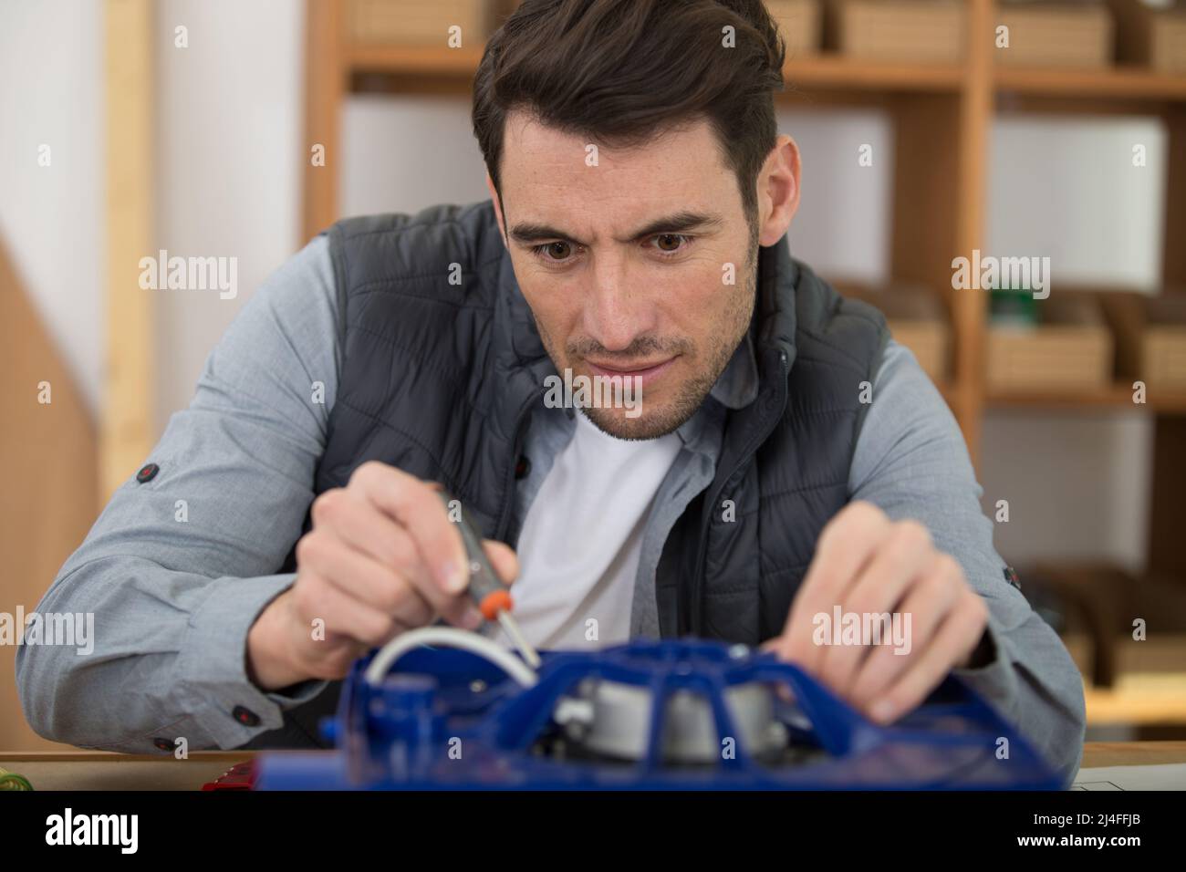 electrician ing workshop working on electrical unit with screwdriver ...