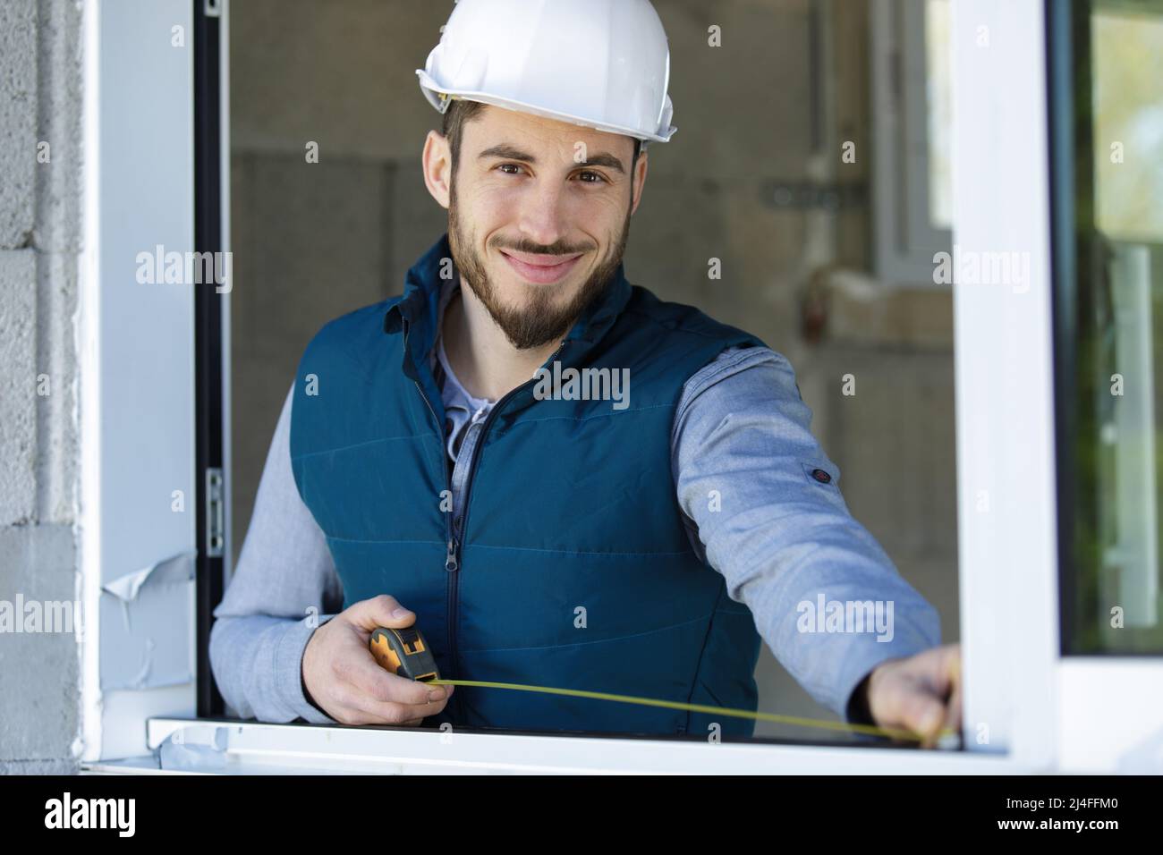 happy construction worker measuring a window Stock Photo - Alamy