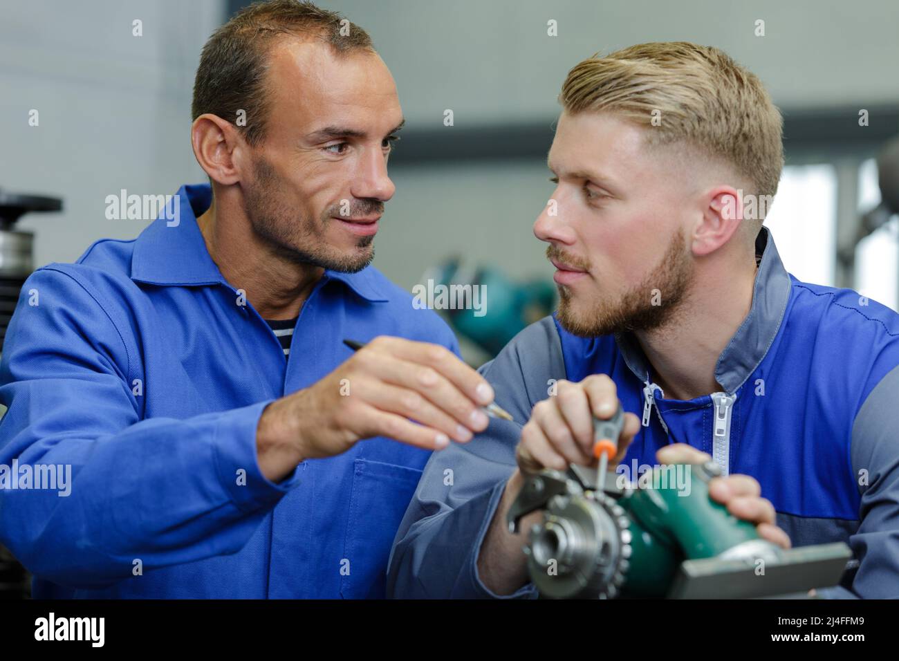 kindly foreman guiding apprentice engineer in his work Stock Photo - Alamy