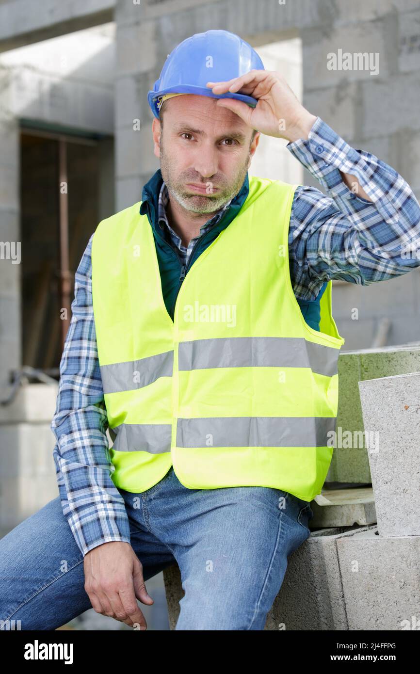 young man builder holds his helmet Stock Photo - Alamy