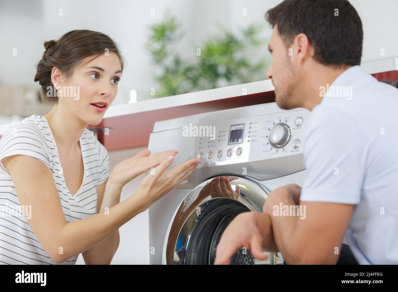 couple talking next to washing machine Stock Photo - Alamy