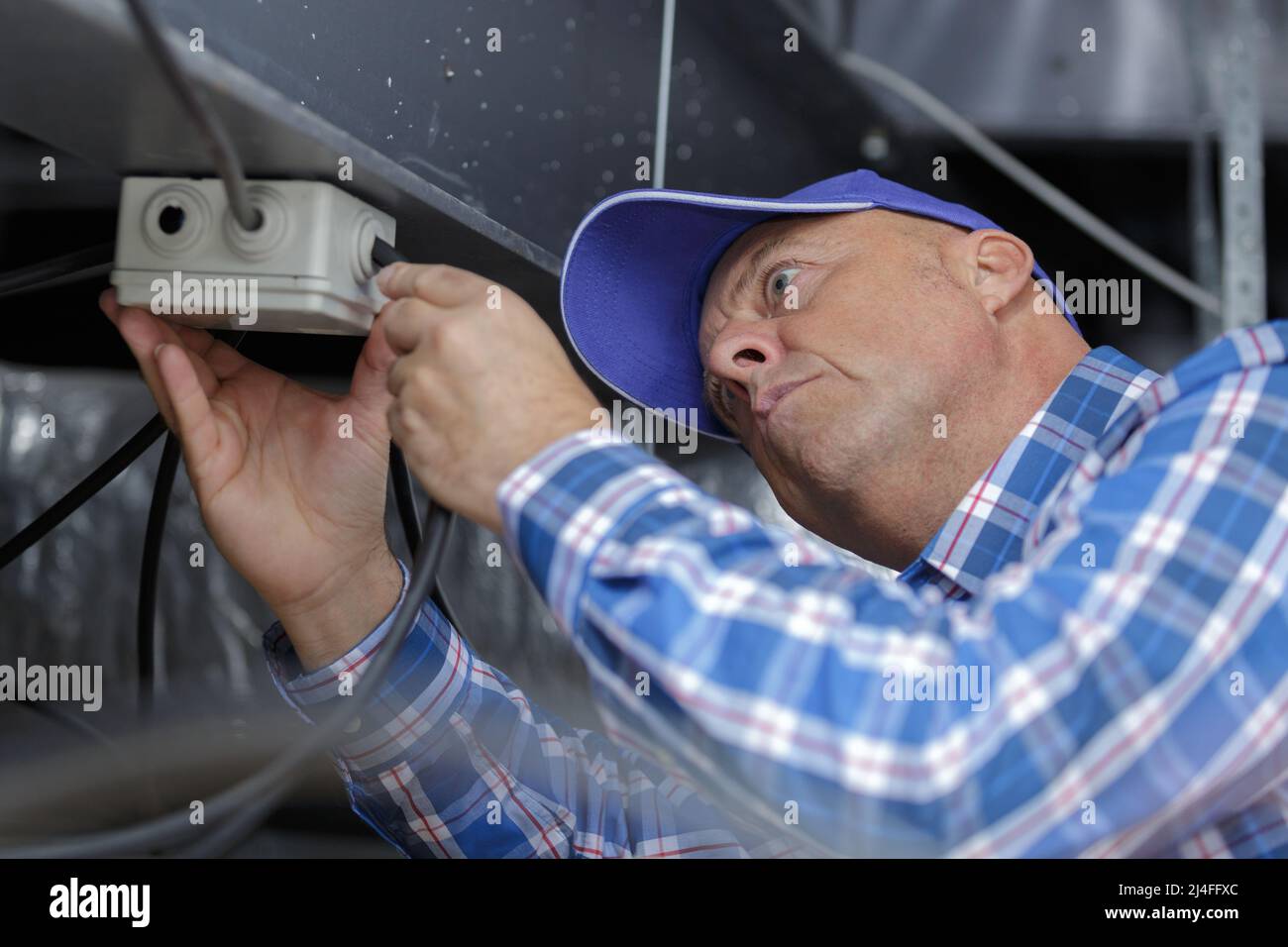 man working with cables and electrical box Stock Photo - Alamy