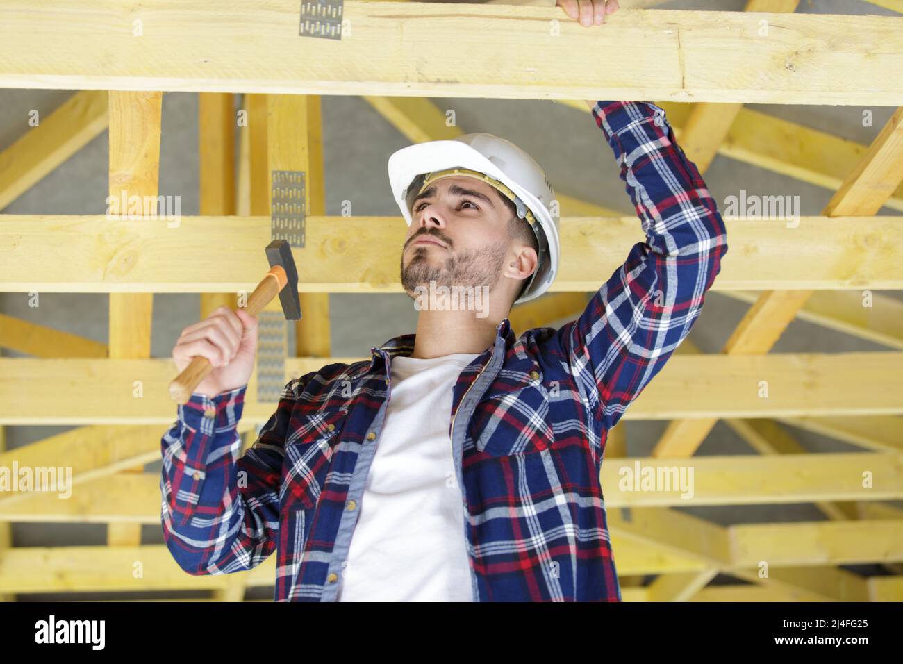 crafty worker using hammer on ceiling Stock Photo - Alamy