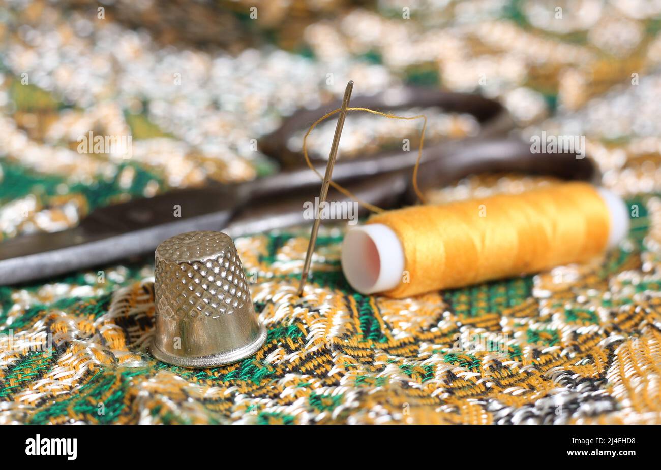 Spool of Golden Thread and Thimble on Vintage Fabric From The Middle ...