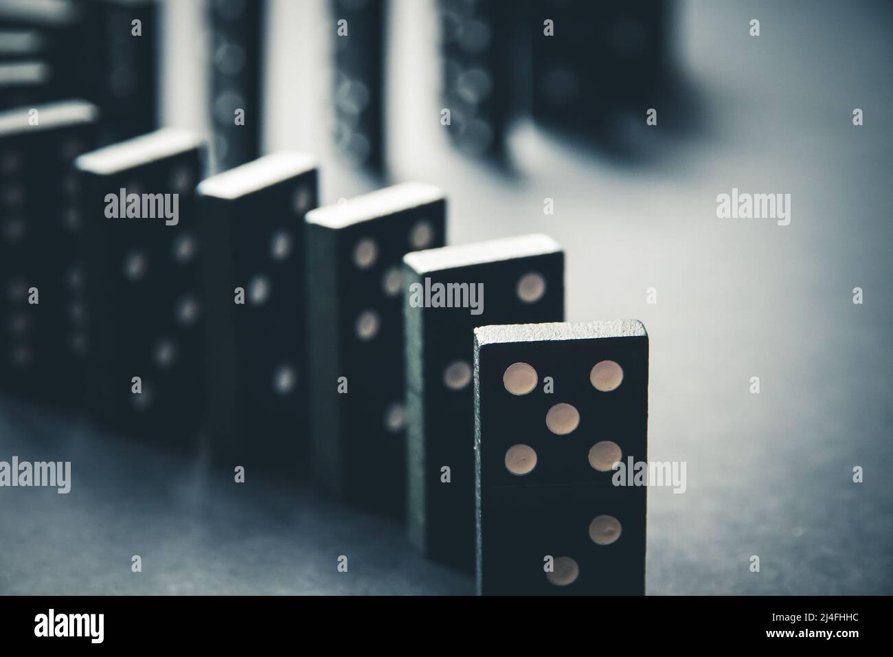 Black dominoes chain on a table background. Domino effect concept Stock ...