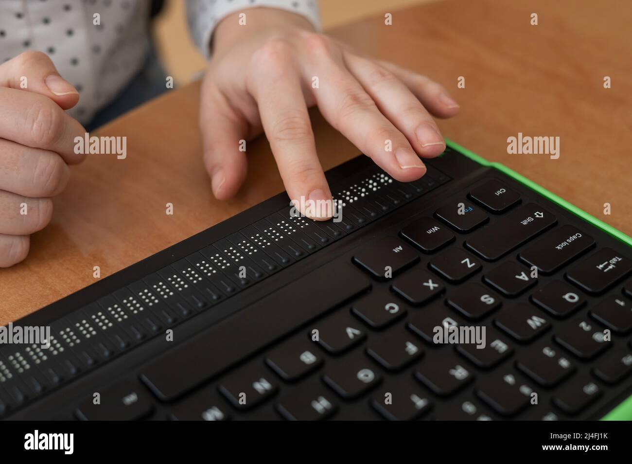 A blind woman uses a computer with a Braille display and a computer ...