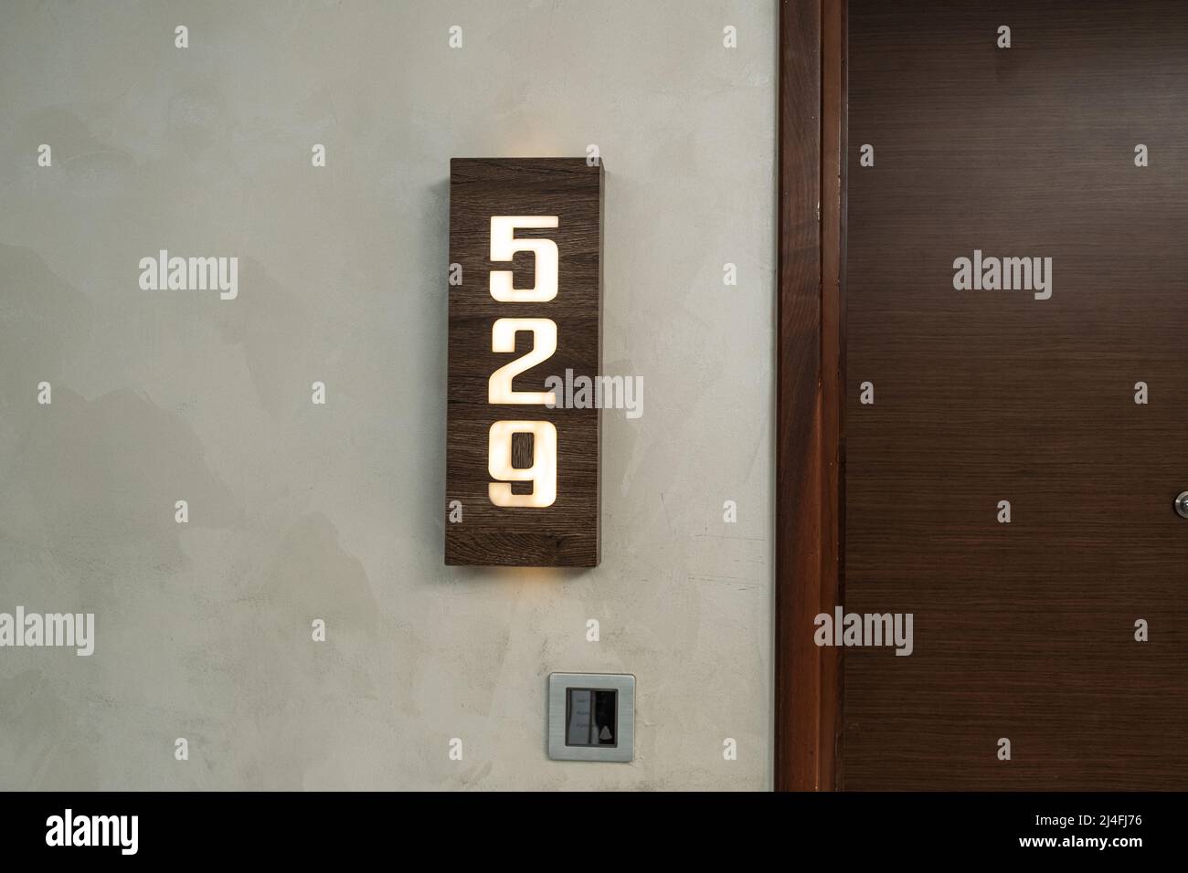 Hotel room number on gray wall Stock Photo - Alamy