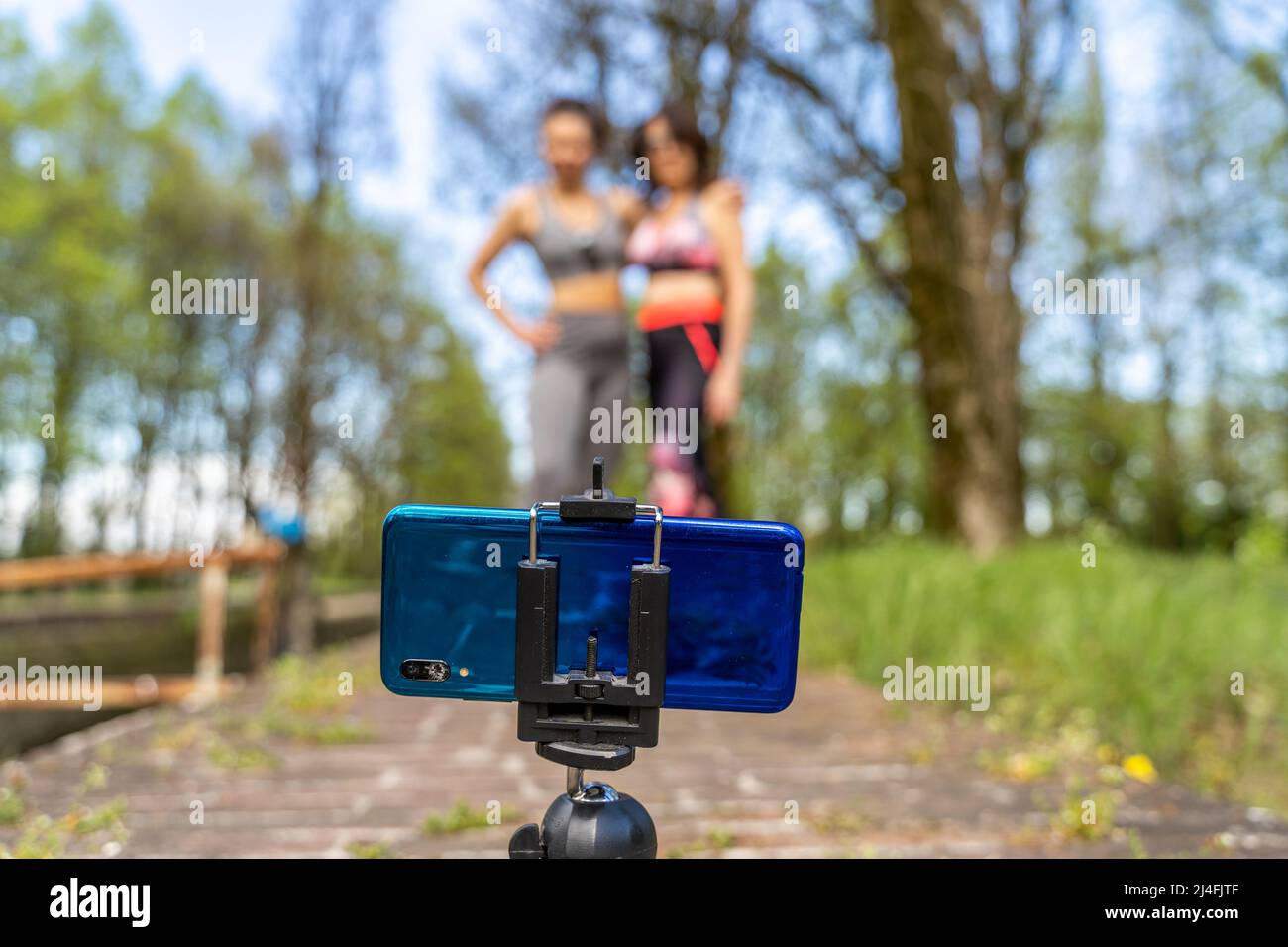 runner mature women taking a selfia with smartphone on a tripod outdoor ...