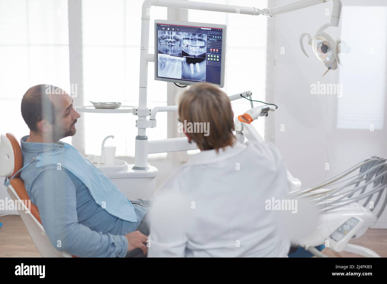 Patient with toothache sitting on dental chair looking at teeth ...