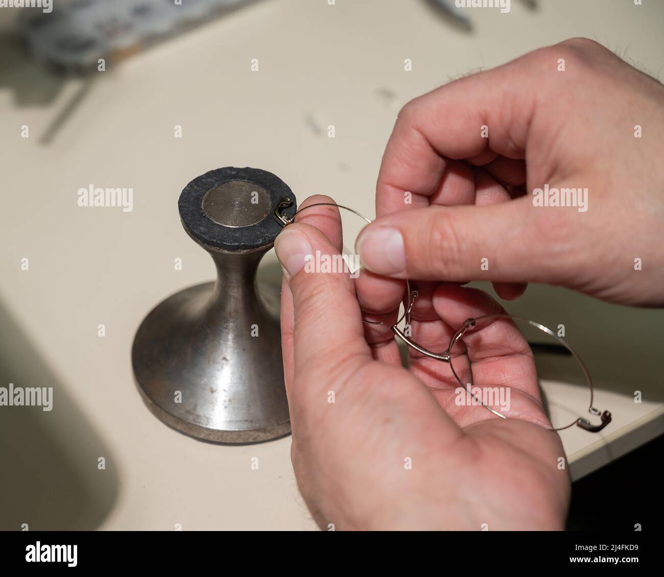 Optical technician fixing glasses. Close-up of male hands with ...