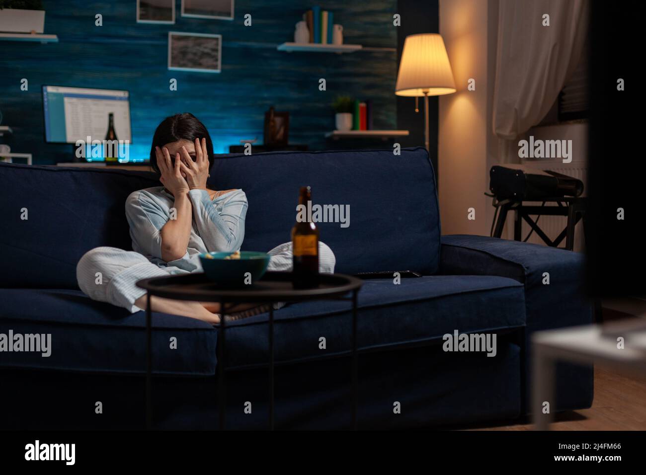 Terrified woman watching scary movie and covering eyes, feeling afraid ...