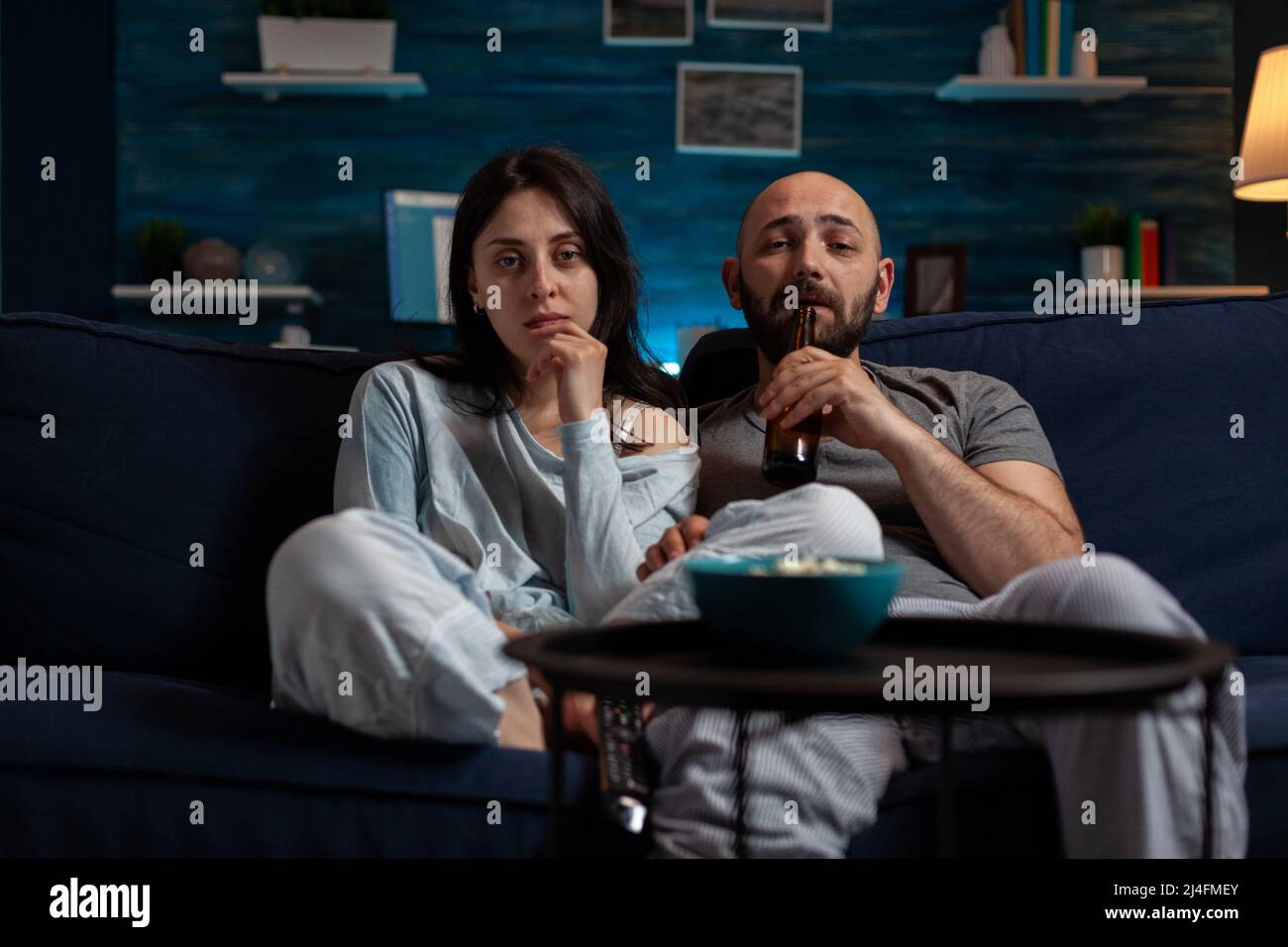 POV of focused girlfriend and boyfriend watching movie on television ...