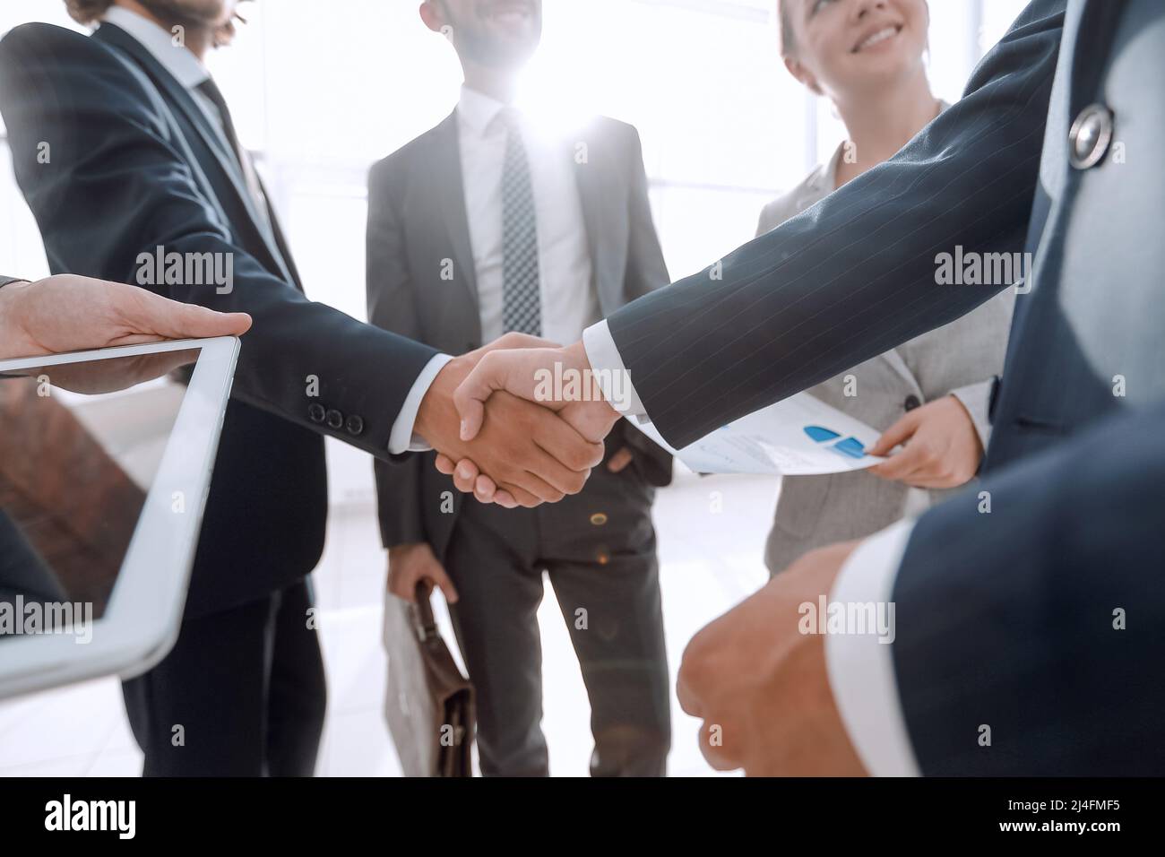 employees look at the handshake business partners Stock Photo - Alamy
