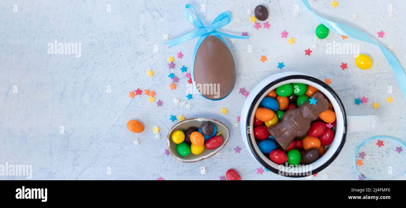 banner with chocolate egg with blue ribbon ears and various chocolate ...