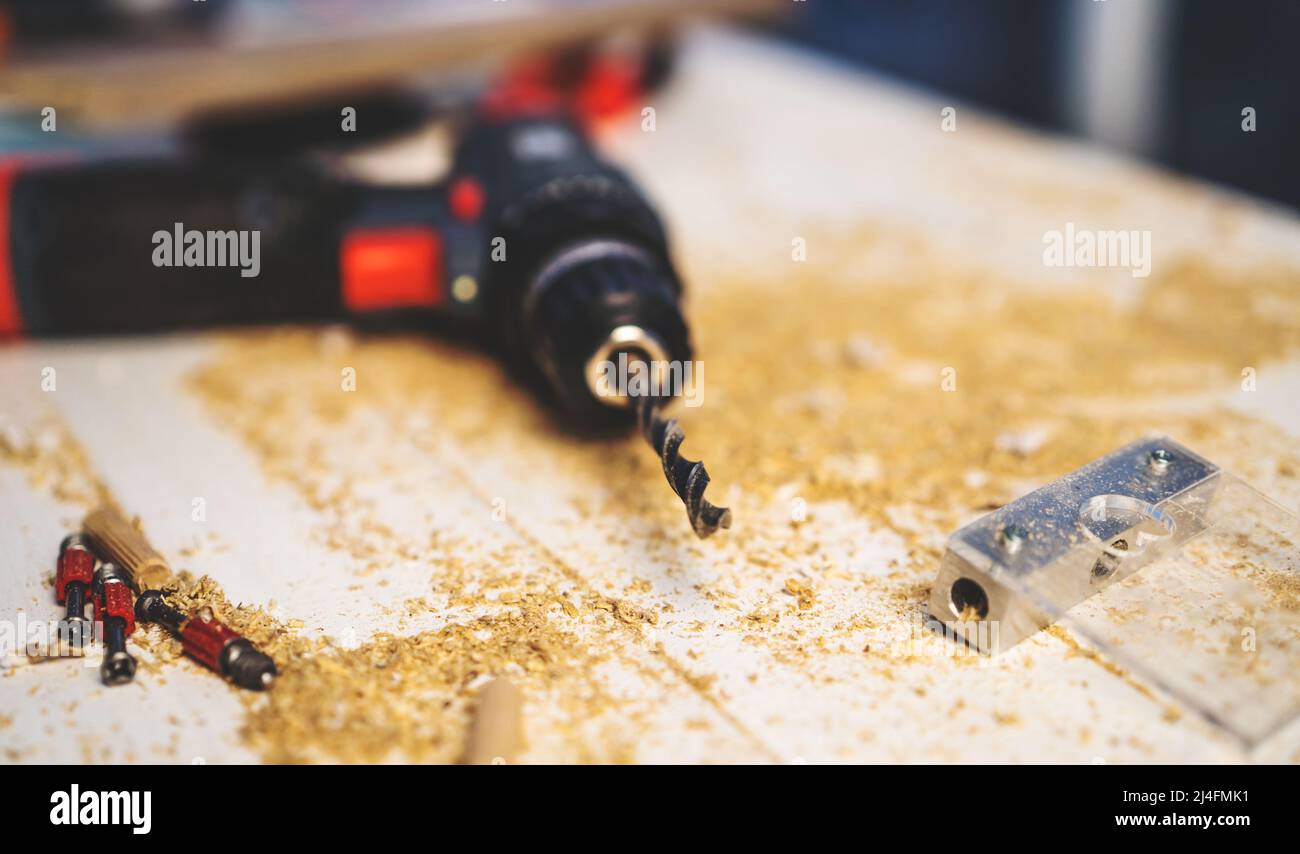 Drill on table with wooden shavings Stock Photo - Alamy