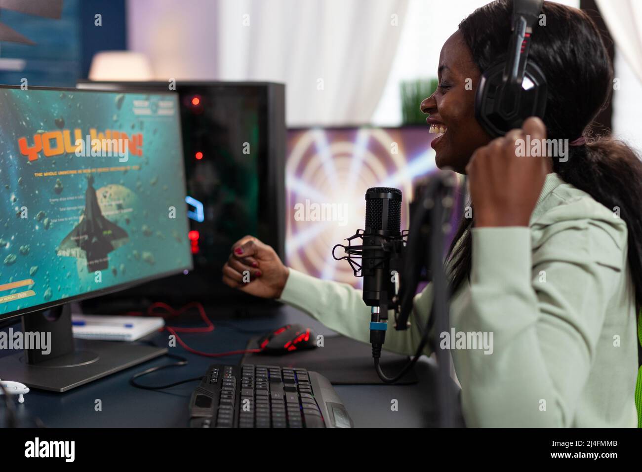 Happy cyber woman winner sitting at gaming desk playing esport ...