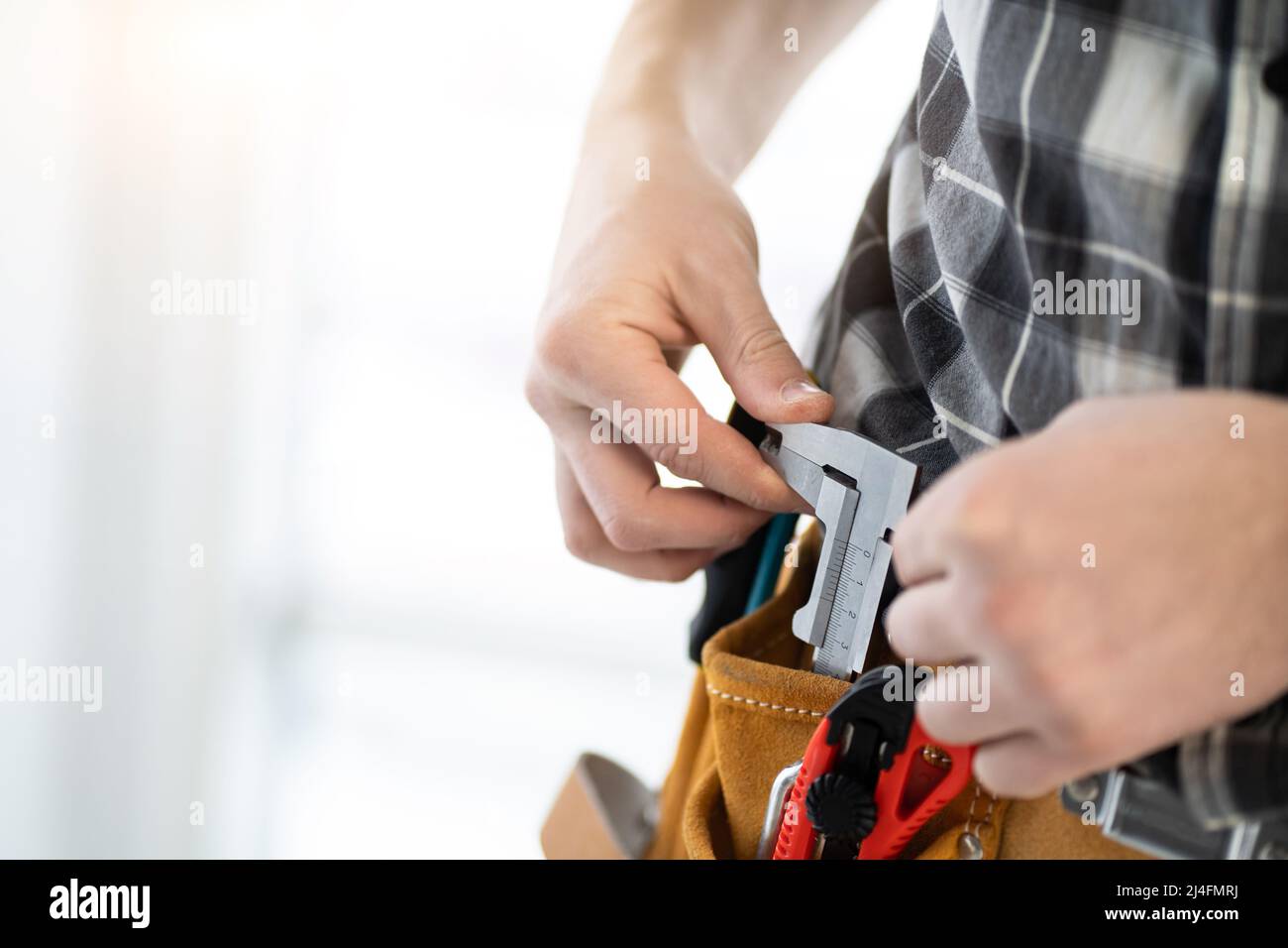 Hand pulling out caliper from belt Stock Photo - Alamy
