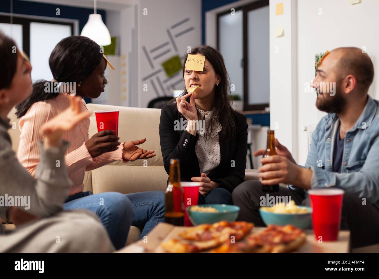 Multiethnic group of friends using sticky notes to play guess who game ...