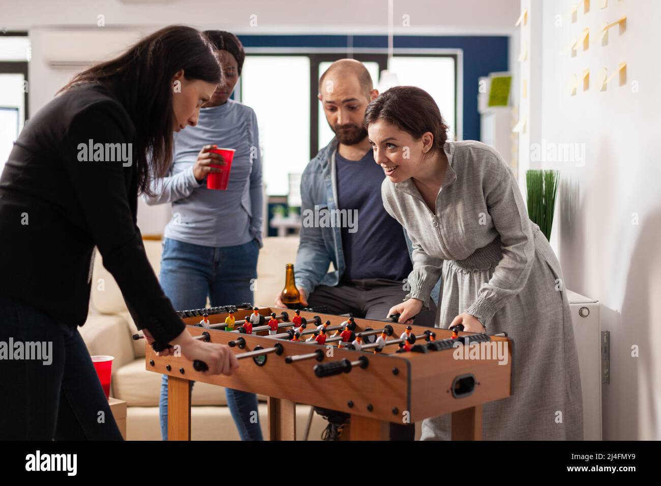 Businesspeople enjoying foosball game competition in office ...
