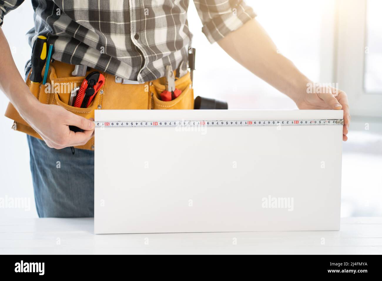 Worker measuring furniture board with tape Stock Photo - Alamy