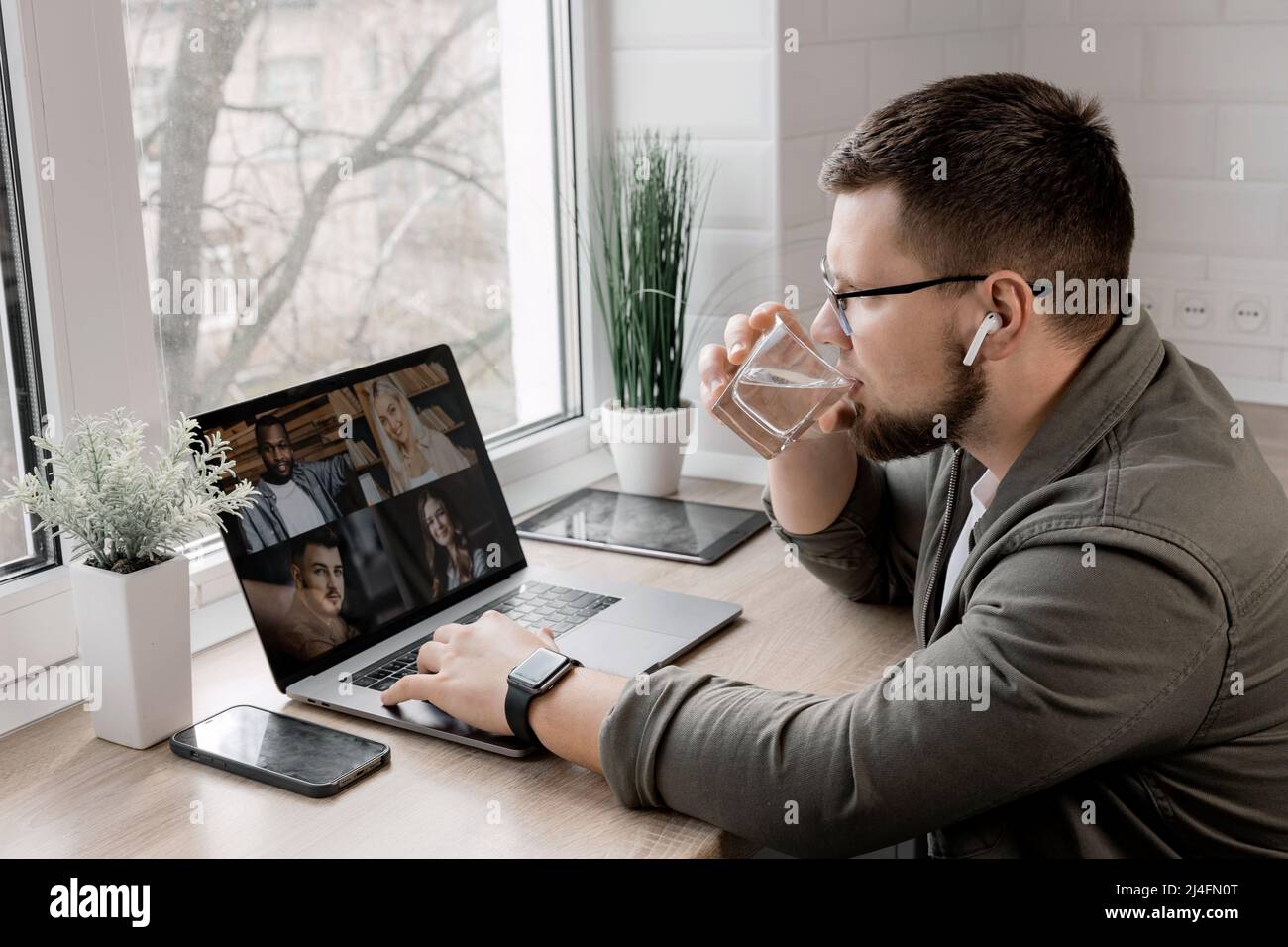 A young guy communicates with his family on the laptop via video ...