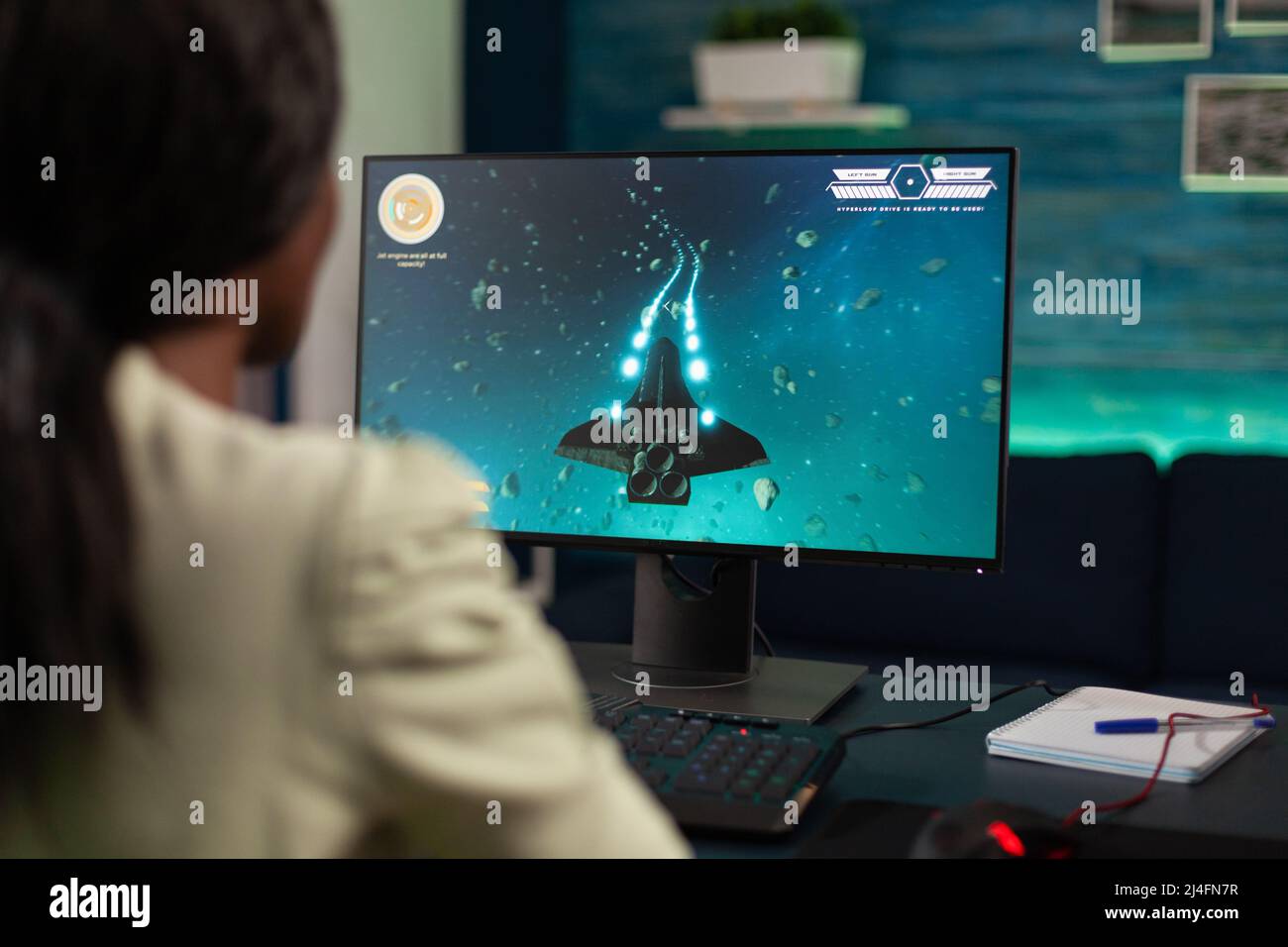 Successful gamer woman holding controller playing space shooter video ...