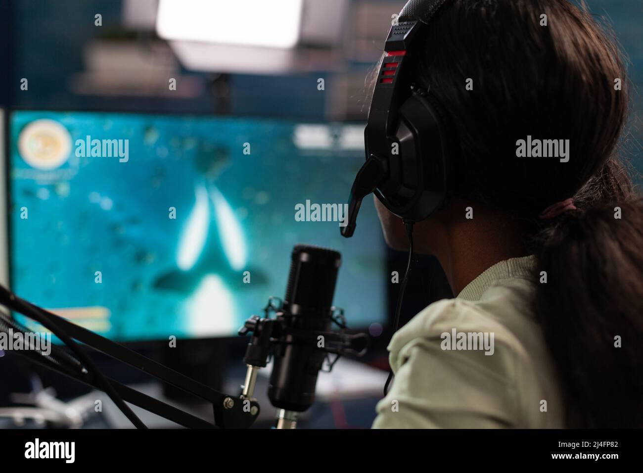 Concentrated pro gamer talking into microphone during live streaming ...