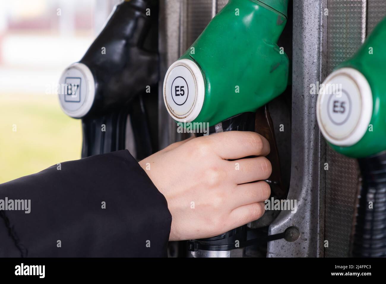 Petrol pump in a petrol station. Close up woman hand take oil dispenser ...