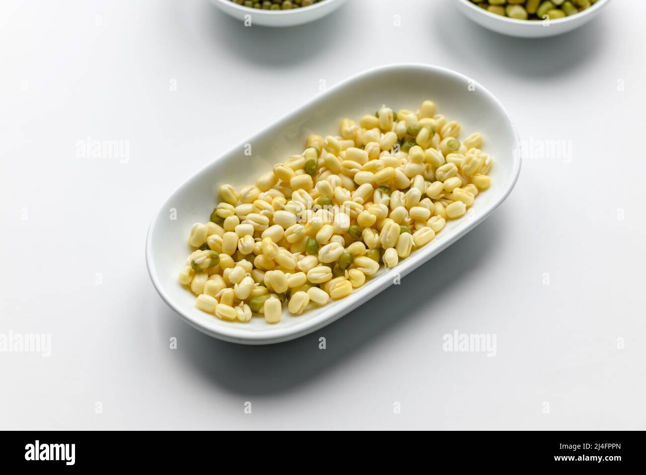 Green mung beans in a bowl on a dark concrete table. Legume plant for a ...