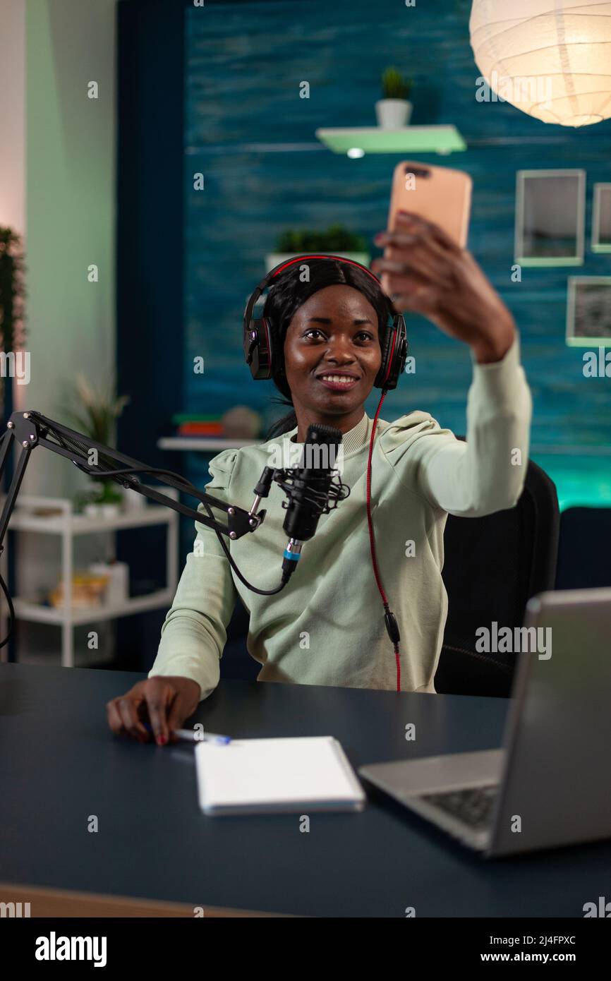 African american vlogger smiling while taking selfie using modern ...