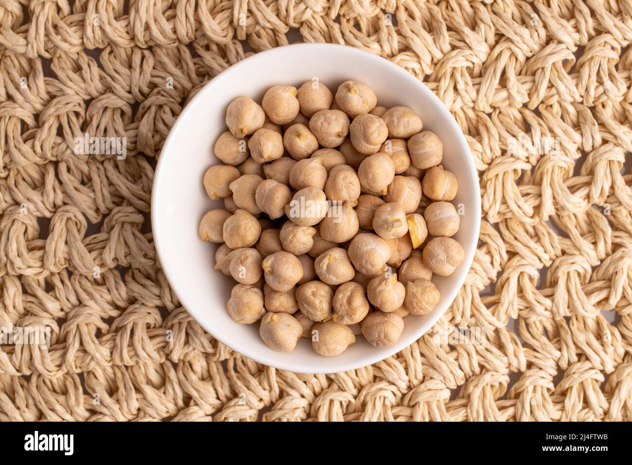Organic natural, uncooked chickpeas in a white saucer, close-up, on a ...