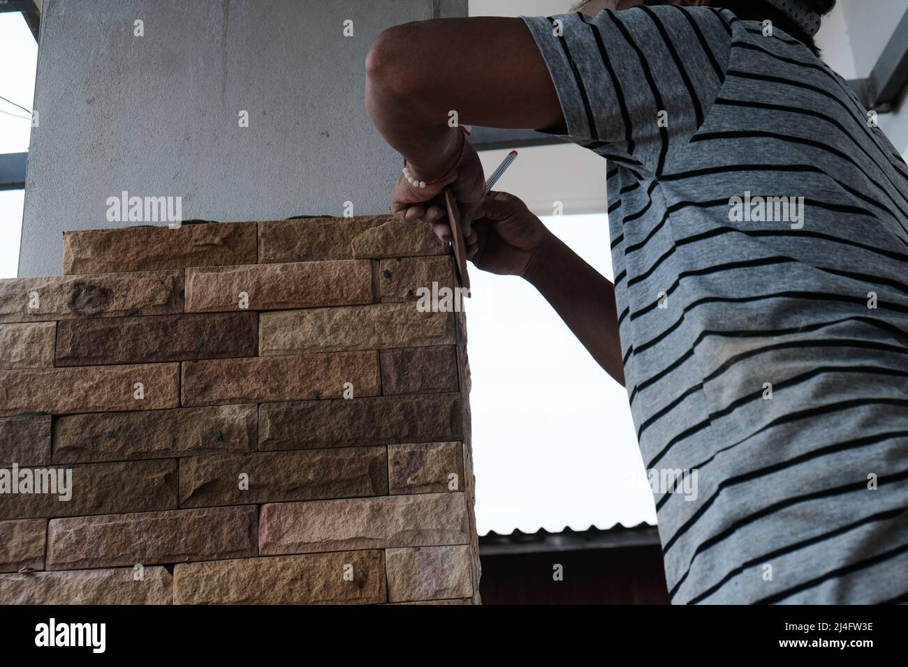 Man working stone tile on new house pole interior building Stock Photo ...