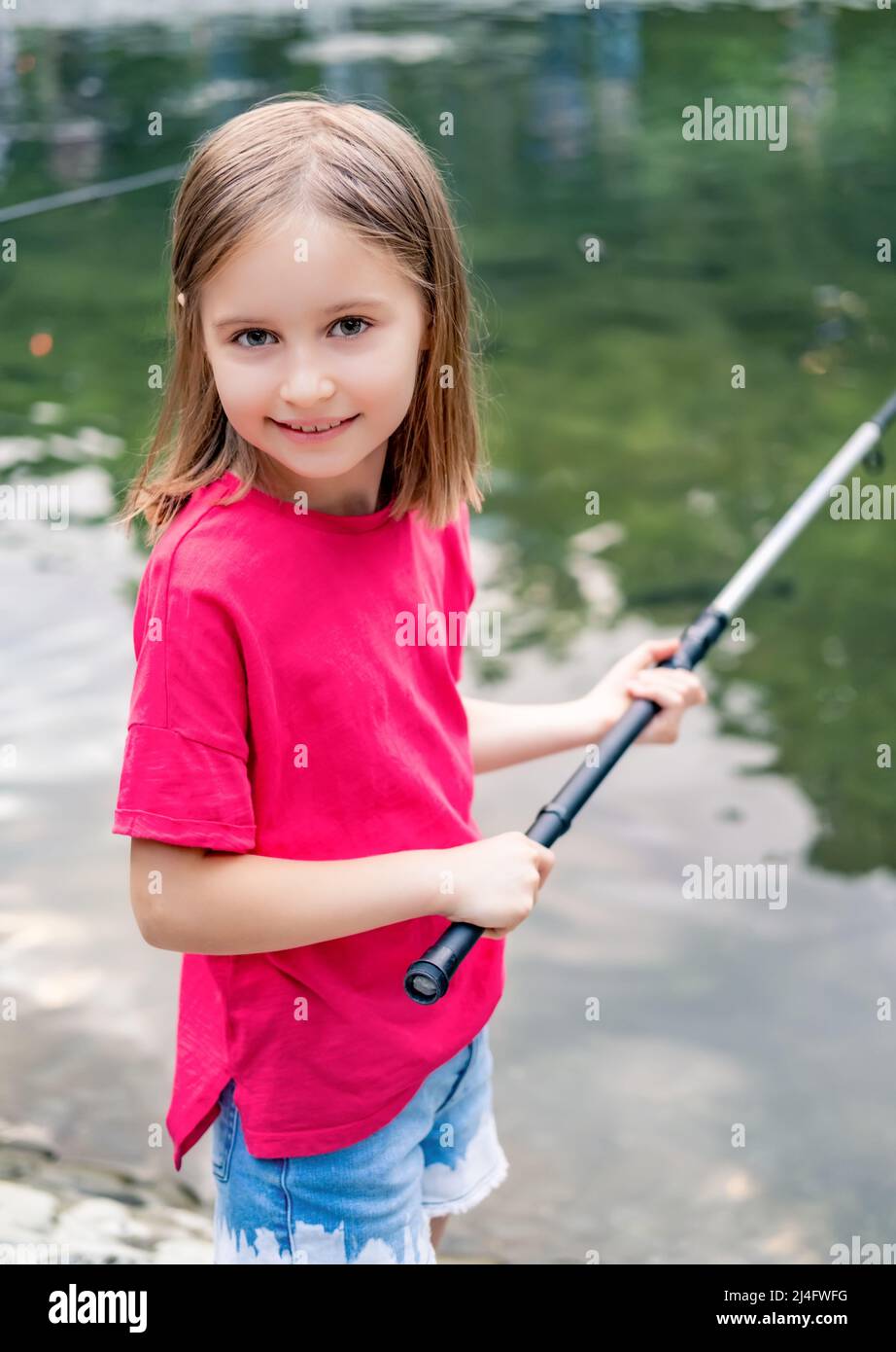 Little girl with rod near river Stock Photo - Alamy
