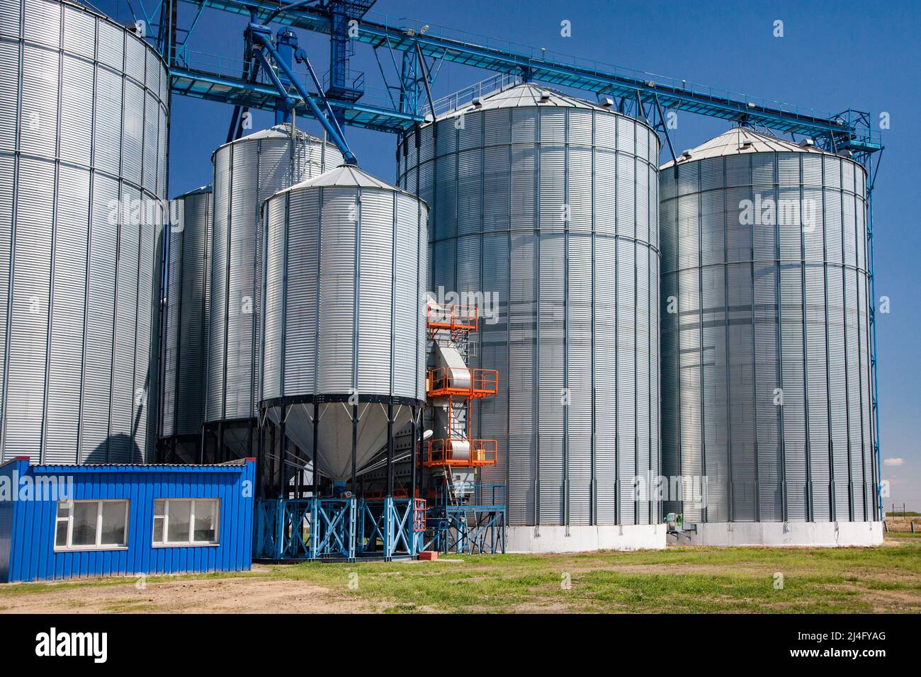 Modern steel grain elevator. Closeup photo. Blue sky Stock Photo - Alamy