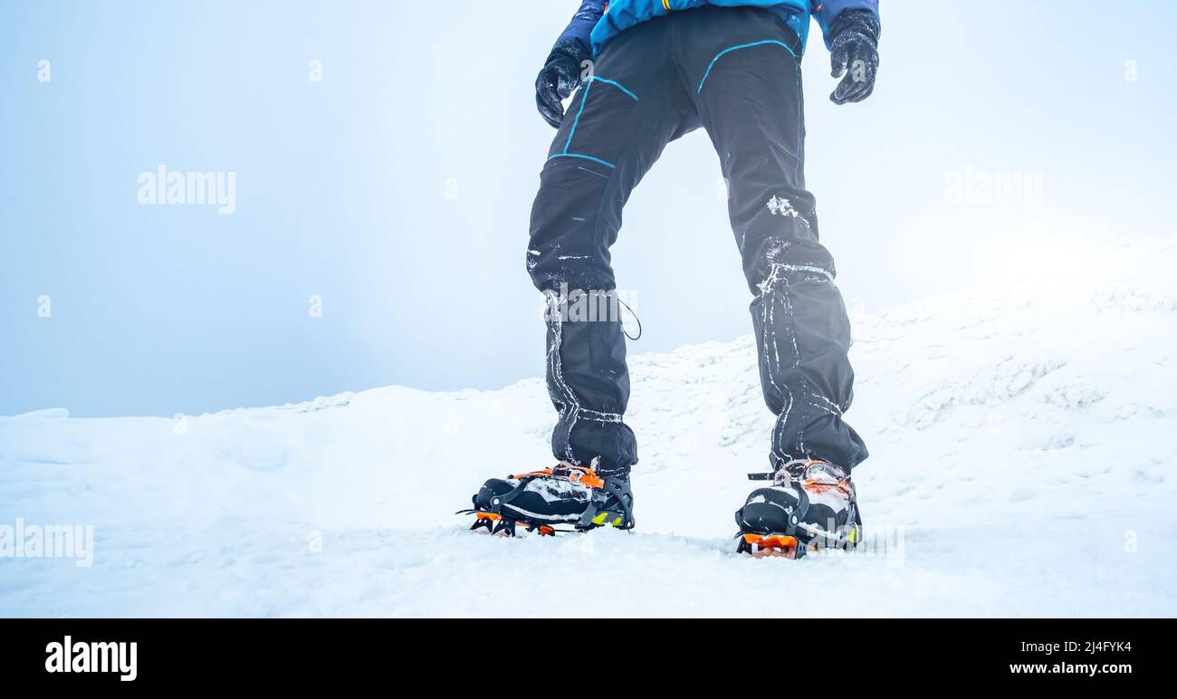 Man trekking snowy mountain using crampons Stock Photo - Alamy