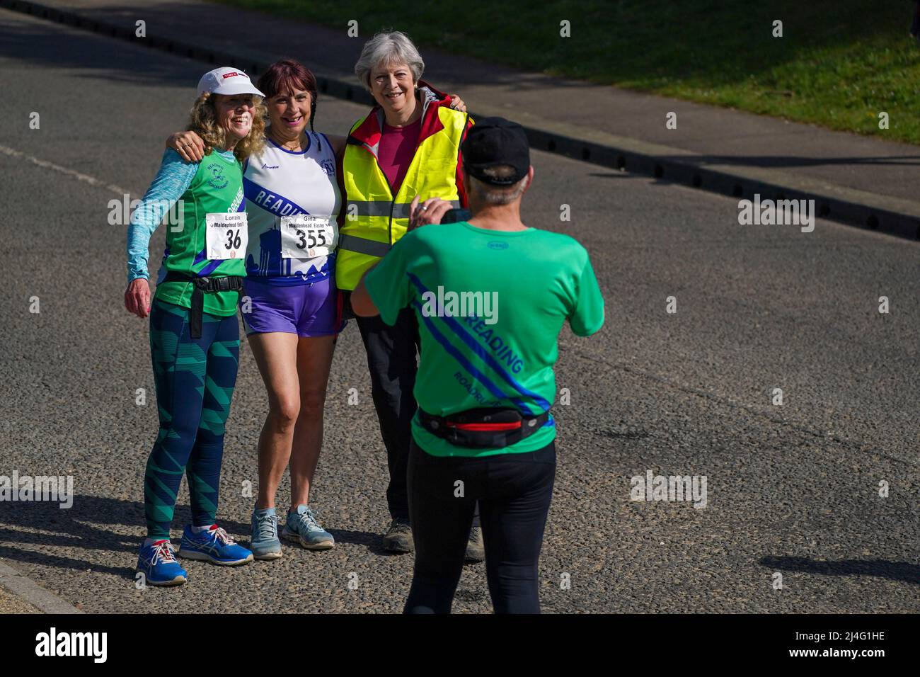 Former prime minister Theresa May poses for photographs with runners as ...